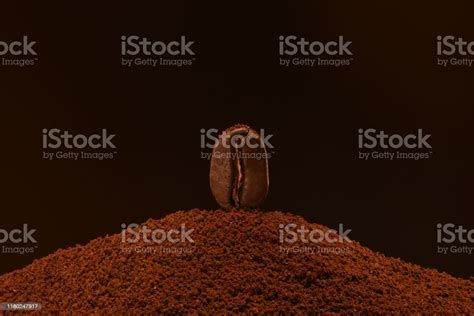 갓 구운 커피 콩은 갈색 배경에 한 줌의 분쇄 커피위에 서 있습니다 격리된 매크로 엽서 배너 공간을 복사합니다 갈색에 대한 스톡 사진 및 기타 이미지 Istock