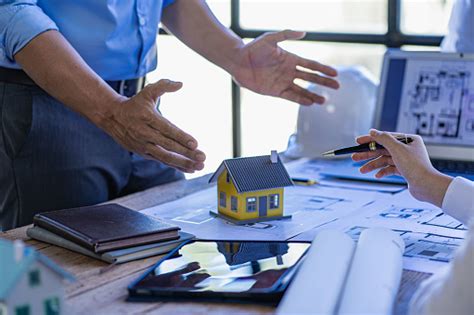 사무실 책상에서 청사진을 논의하고 검토하는 동료를 위한 엔지니어링 팀 회의 작업장에서 건설 및 개조 건물 프로젝트를 계획하는