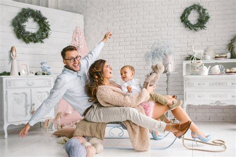 Молодая счастливая семья с младенцем в студии оформления рождества