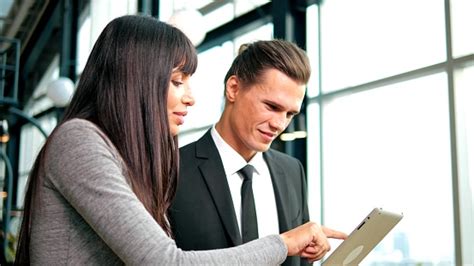 두 명의 비즈니스 동료가 함께 프로젝트를 진행하고 책상에 앉아 노트북 화면을 보고 전략을 논의하고 사무실에서 아이디어를