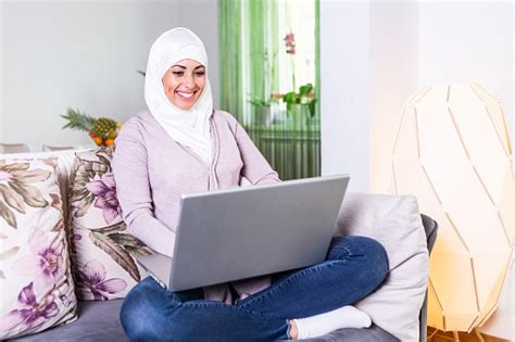 노트북 컴퓨터와 서류 에서 일하는 매력적인 여성 아랍어 책상 집에서 일하는 무슬림 사업가 헌신과 기술 작업을 수행하는 데 필수적입니다 개성 개념에 대한 스톡 사진 및 기타