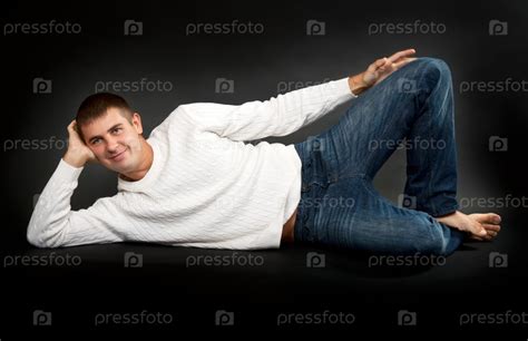 Фотография на тему Мужчина лежит на полу черный фон Pressfoto