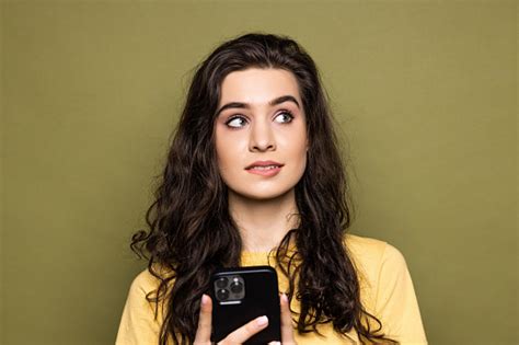 좌절한 충격을 받은 여자는 카메라를 바라보는 카키색 배경에 스마트폰을 손에 들고 있다 나쁜 소식 부정적인 인간의 감정 개념 단순함에 대한 스톡 사진 및 기타 이미지 Istock