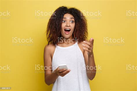 라이프 스타일 개념충격적인 아름 다운 아프리카계 미국인 여자의 초상화 누군가 하 고 휴대 전화를 들고을 참조 하십시오 옐로우 파스텔 스튜디오 배경입니다 공간에 복사 합니다