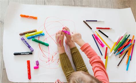 바닥에 앉아 있는 어린 소녀는 창의력을 즐기며 종이에 연필로 그림을 그립니다 맨 위 보기 아이에 대한 스톡 사진 및 기타 이미지 아이 어린 시절 종이 Istock