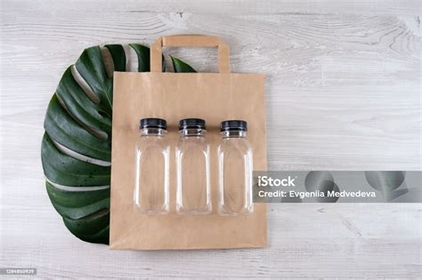 갈색 종이 에코 백에 3 개의 플라스틱 병 로고를 위한 장소 복사 공간이 있는 회색 배경에 친환경 식품 포장 및 면 에코 백