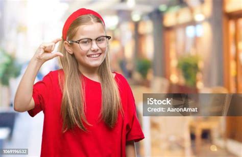 격리 된 배경 웃 고 자신감 생기고 카메라 동안 손가락으로 크기 표시를 하 고 손으로 몸짓에 안경을 쓰고 젊은 아름 다운 소녀 측정 개념입니다 개념에 대한 스톡 사진 및