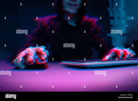 Hacker In The Hood Working With Computer Typing Text In Dark Room Image With Glitch Effect