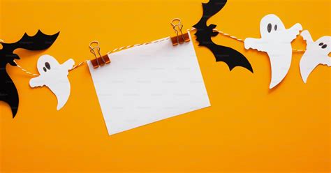 해피 할로윈 개념입니다 할로윈 장식 클립에 빈 종이 카드 박쥐 주황색 배경에 유령 복사 공간이 있는 할로윈 파티 인사말 카드 모형 평평한 누워 평면도 오버