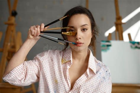 Headshot Portrait Of Young Woman Artist Holding Paintbrush Near Her