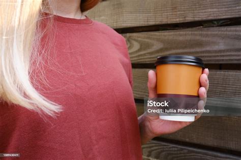 여자의 손에 커피가 든 종이 컵 도시에서 커피를 마실 시간 갈 커피 순간을 즐기고 휴식을 취하십시오 일회용 종이컵 클로즈업 맛있는 뜨거운 음료 텍스트의 빈 공간 소녀에 대한