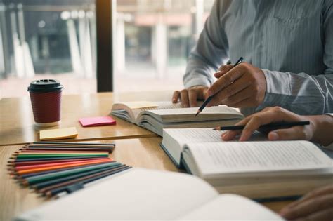 Premium Photo Midsection Of Students Studying On Table