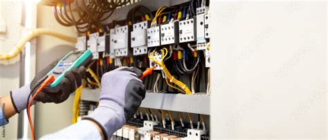 Electrical Engineer Using Digital Multi Meter Measuring Equipment To Checking Electric Current