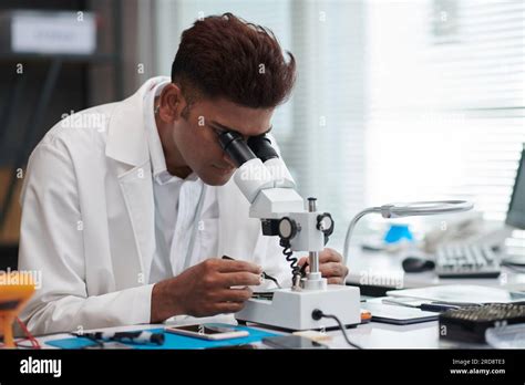 Engineer Looking Through Microscope When Repairing Hard Drive Stock
