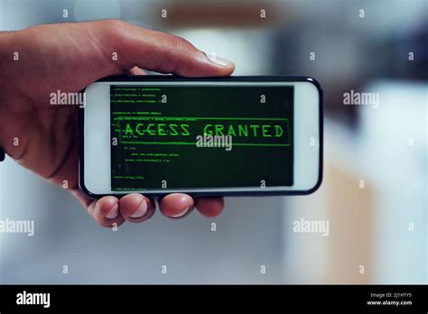 Not Even Your Smartphone Is Safe Shot Of An Unidentifiable Man Using A Smartphone To Hack Into