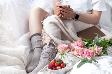 침대 딸기의 열매와 향기로운 모닝 커피에 여자의 손에 핑크 장미 꽃다발 로맨틱 침대에서 아침 식사입니다 빈티지 사진입니다 공간 복사 가정의 방에 대한 스톡 사진 및 기타