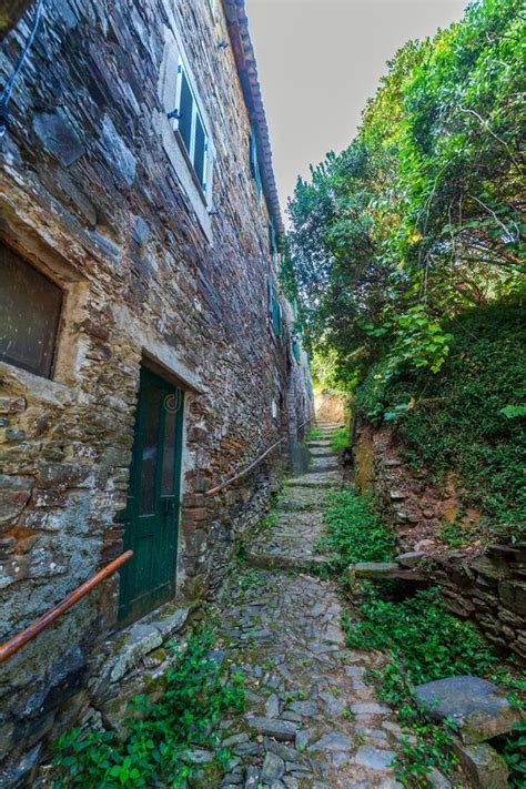 A Narrow Cobblestone Alley Winds Steeply Uphill Between Ancient Stone