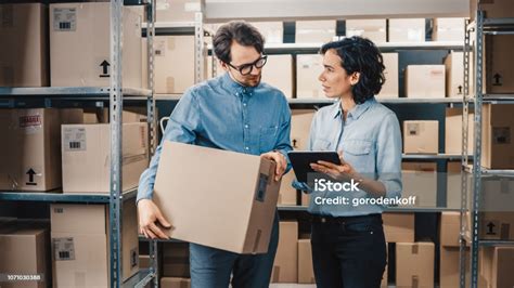골 판지 상자를 들고 노동자 여성 재고 관리자 쇼 디지털 태블릿 정보 그들은 이야기 하 고 일 배경 주식에서의 선적을 위한 제품 가능한 소포 체크리스트에 대한 스톡 사진 및