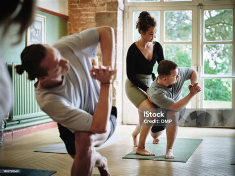 요가 스튜디오 강사가 학생과 스트레칭을 수업 여성과 운동에 도움을줍니다 가르치고 마음과 유연성 마음 챙김과 신체에 대한 활동 건강과 균형 원조에 대한 스톡 사진 및 기타