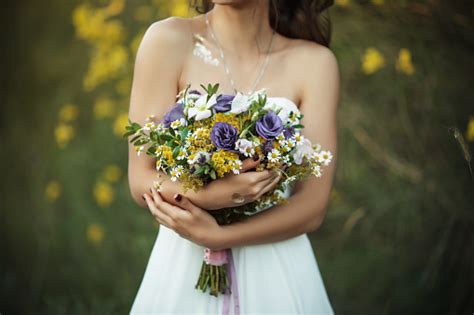 석양 빛에 필드에 야생화의 꽃다발과 아름 다운 젊은 신부 갈색 머리에 대한 스톡 사진 및 기타 이미지 갈색 머리 결혼식 꽃 식물 Istock