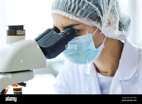 Close Up Portrait Of Female Scientist Looking In Microscope While Working In Medical Laboratory
