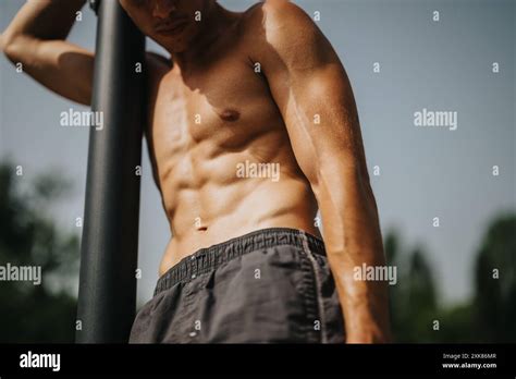 Athletic Young Man Showing Defined Abs And Muscular Physique Outdoors