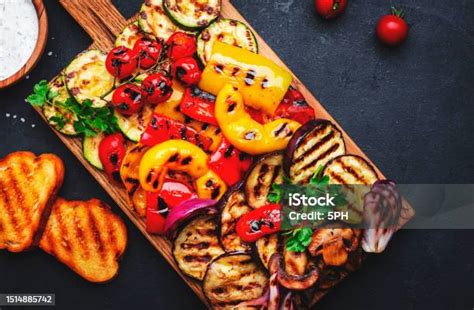 소박한 나무 도마에 구운 야채 화려한 파프리카 호박 가지 버섯 토마토 적양파와 요구르트 드레싱 검은 돌 테이블 배경 탑 뷰 0명에 대한 스톡 사진 및 기타 이미지 Istock