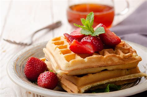 시럽을 따로 흰색 나무 부엌 테이블에 딸기와 민트 잎과 함께 제공되는 벨기에 와플의 클로즈업 보기 와플에 대한 스톡 사진 및 기타 이미지 Istock