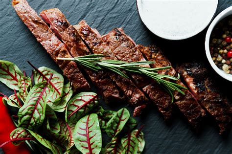 얇게 썬 구운 스테이크 중간 희귀 야채와 함께 블랙 커팅 보드에 제공됩니다 Steakhouse에 대한 스톡 사진 및 기타 이미지 Steakhouse 건강한 식생활