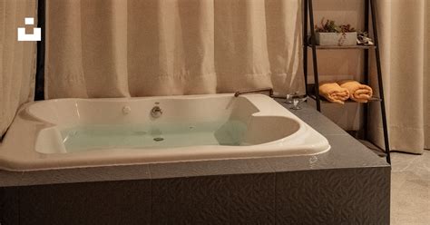 창문 옆에 대형 자쿠지 욕조가 있는 욕실 사진 Unsplash의 무료 칼빌로 이미지