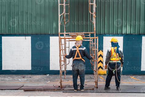 Construction Worker Wearing Safety Harnesses With Scaffolding At Construction Site Working At