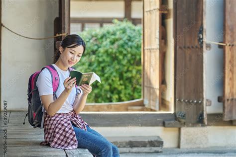 한국의 옛날 전통 가옥 마루에 걸터 앉아서 여권 과 항공권을 바라보고 있는 아시아 한국 여자 모델 Foto De Stock Adobe Stock