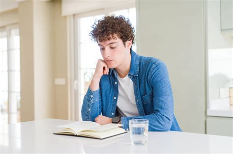 질문에 대해 생각 하는 심각한 얼굴 집에서 책을 읽고 젊은 남자 매우 혼란 스러운 아이디어 사색에 대한 스톡 사진 및 기타 이미지 Istock