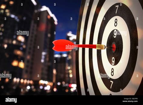 Red Dart Hitting Target On Board Against Blurred Of View Night Cityscape Stock Photo Alamy