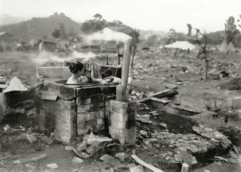 1923年、関東大震災直後の東京・有楽町付近。住民らは家財道具を道路に持ち出していた。左では家屋が倒壊し、右後方の一色活版所ビルからは煙が