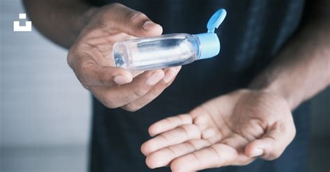 파란색 뚜껑이 있는 투명한 유리병을 들고 있는 사람 사진 Unsplash의 무료 손 이미지