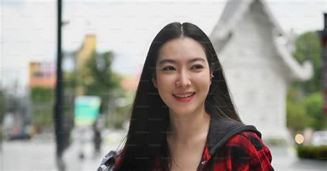 쇼핑백을 들고 도시 거리를 걷고 있는 웃고 있는 젊은 여성의 초상화 사진 Unsplash의 성공 이미지