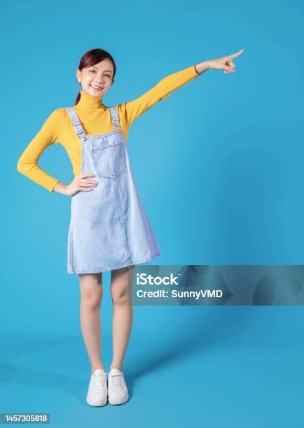 파란색 배경에 서 있는 어린 아시아 소녀의 전체 길이 사진 가리키기에 대한 스톡 사진 및 기타 이미지 가리키기 전신 20 24세 Istock