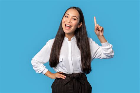 자유형 젊은 여자 를 입고 셔츠 와 스커트 서 고립 에 푸른 가리키는 올라 에 복사 공간 포즈 에 카메라 즐거운 갈색 머리에