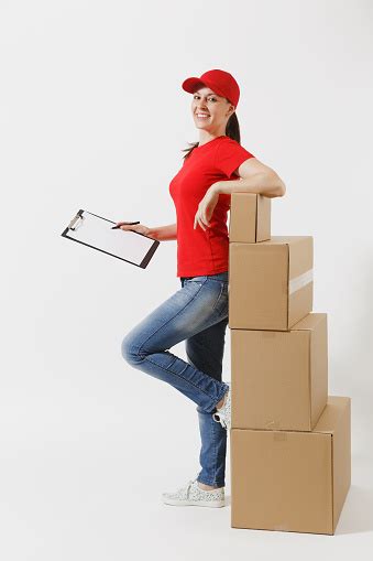 빨간 모자에 배달 여자의 전체 길이 T셔츠는 흰색 배경에 고립 여성 택배 종이 문서 빈 골 판지 상자에 빈 빈 시트와 클립보드를 들고 수신 패키지입니다 가냘픈에 대한 스톡