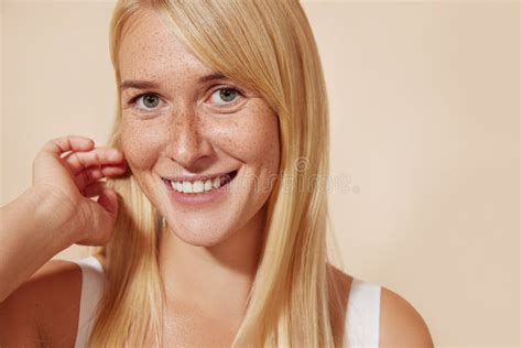 Close Up Of A Young Freckled Female Looking Straight At A Camera In The