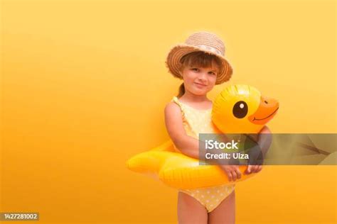 수영복을 입은 어린이 소녀는 노란색 배경에 오리 모양의 풍선 반지가있는 밀짚 모자를 쓰고 있습니다 복사 공간 6 7 살에 대한 스톡 사진 및 기타 이미지 Istock