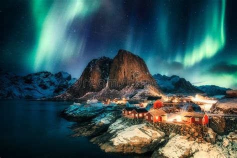 Aurora Borealis Northern Lights Over Mountain With Fishing Village On