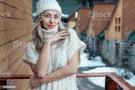 발코니의 거리에서 흰색 모자와 스웨터를 입은 아름다운 소녀의 초상화 따뜻한 겨울 옷 겨울에 대한 스톡 사진 및 기타 이미지