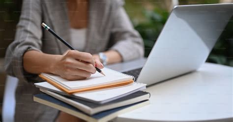 노트북 컴퓨터에서 작업하고 노트북에 메모를 하는 사업가의 잘린 샷 사진 Unsplash의 태국 이미지