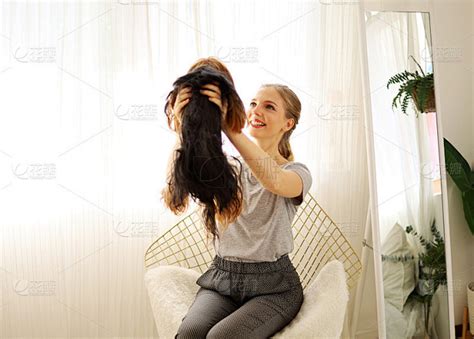 幸福年轻的女人在家里玩他们最喜欢的狗。