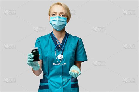 医生护士妇女戴着防护面具和橡胶或乳胶手套 持有药丸