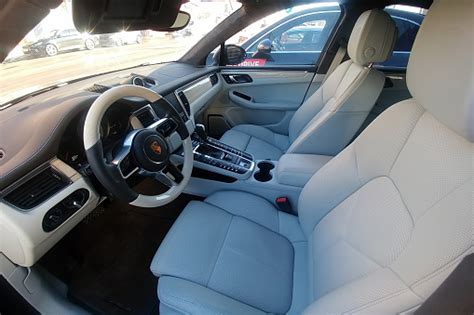 거리에 주차 된 프리미엄 Suv 포 르 쉐 마 쿠의 화이트 가죽 인테리어 화이트 오크 나무와 나무로 되는가 열 스티어링 휠의 패키지 트림 자동차 고급 자동차에 대한 스톡