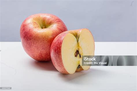 깨끗한 흰색 표면과 밝은 배경에 씨앗이 있는 전체 빨간 사과와 반 컷 사과는 육즙이 많은 질감 신선한 과육 및 잘 익은 건강한 과일의 자연스러운 색상을 보여줍니다 겉껍질에