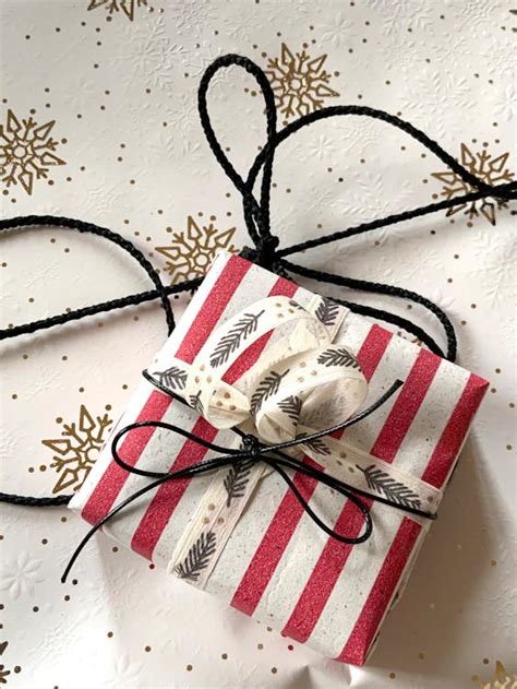 빨간 줄무늬와 검은 리본이 있는 축제 선물 상자 · 무료 스톡 사진